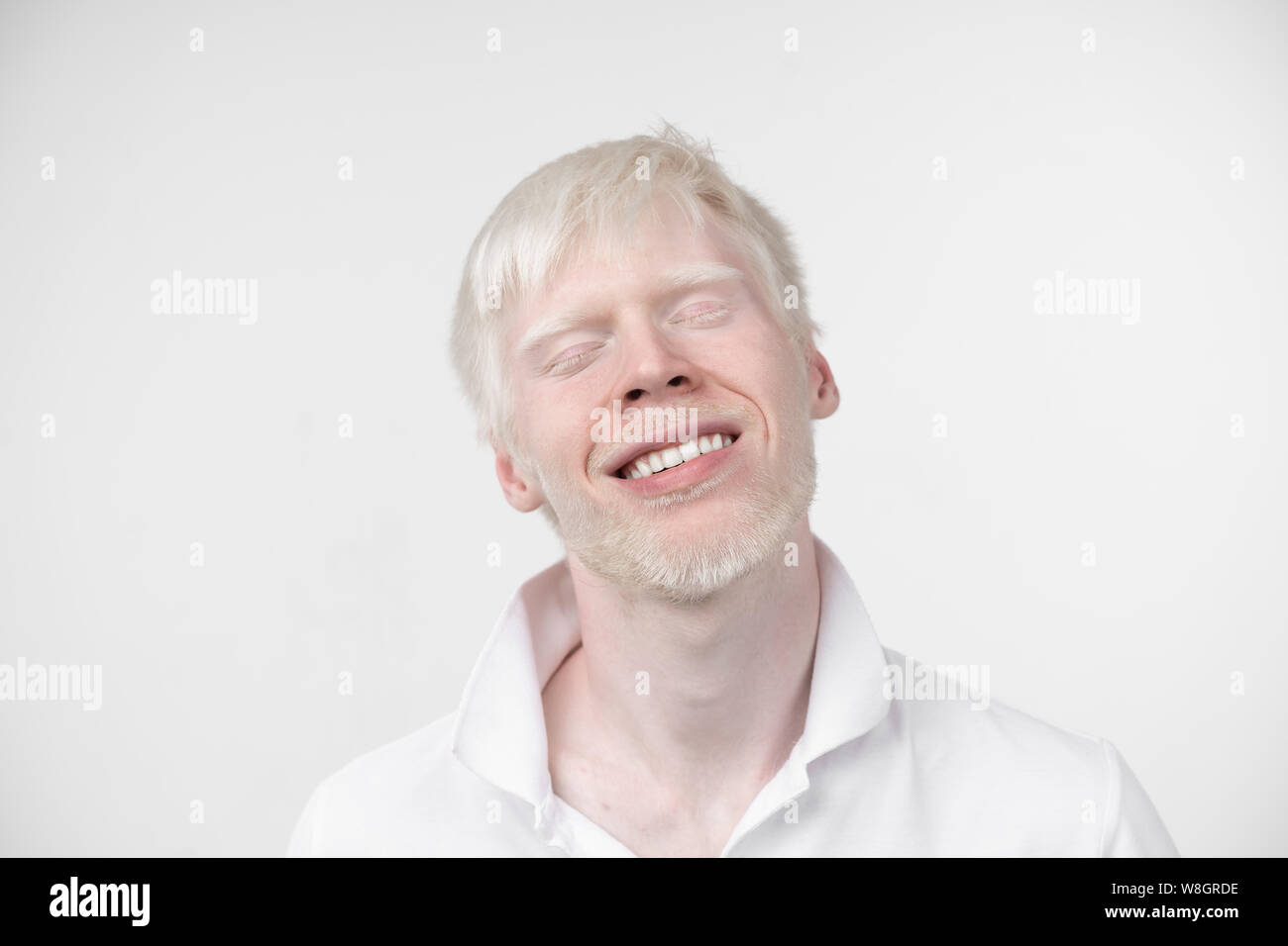 portrait of an albino man in studio dressed t-shirt isolated on a white ...