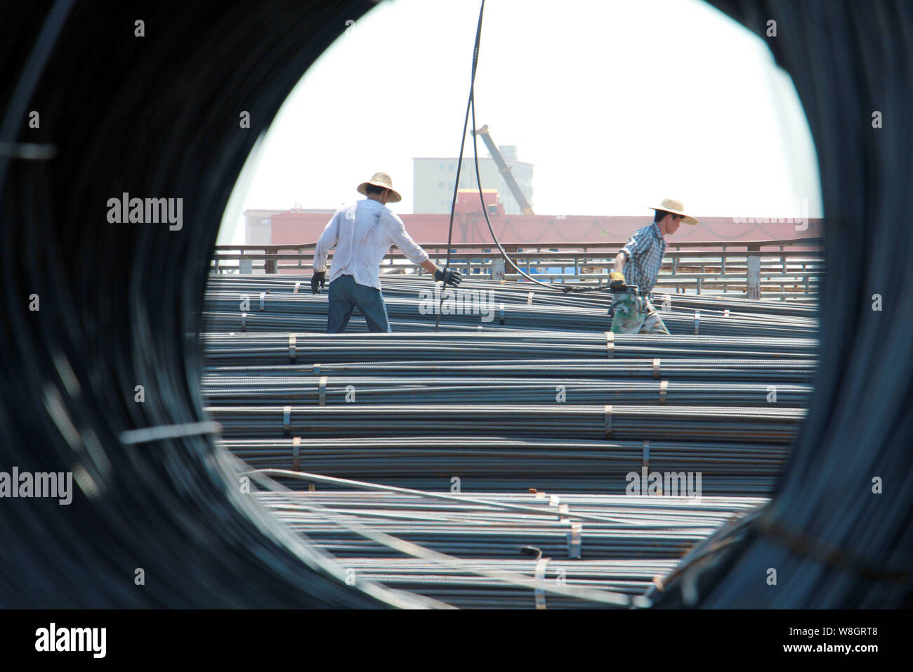 --FILE--Chinese workers bind reinforcing steel rods to be lifted at a ...