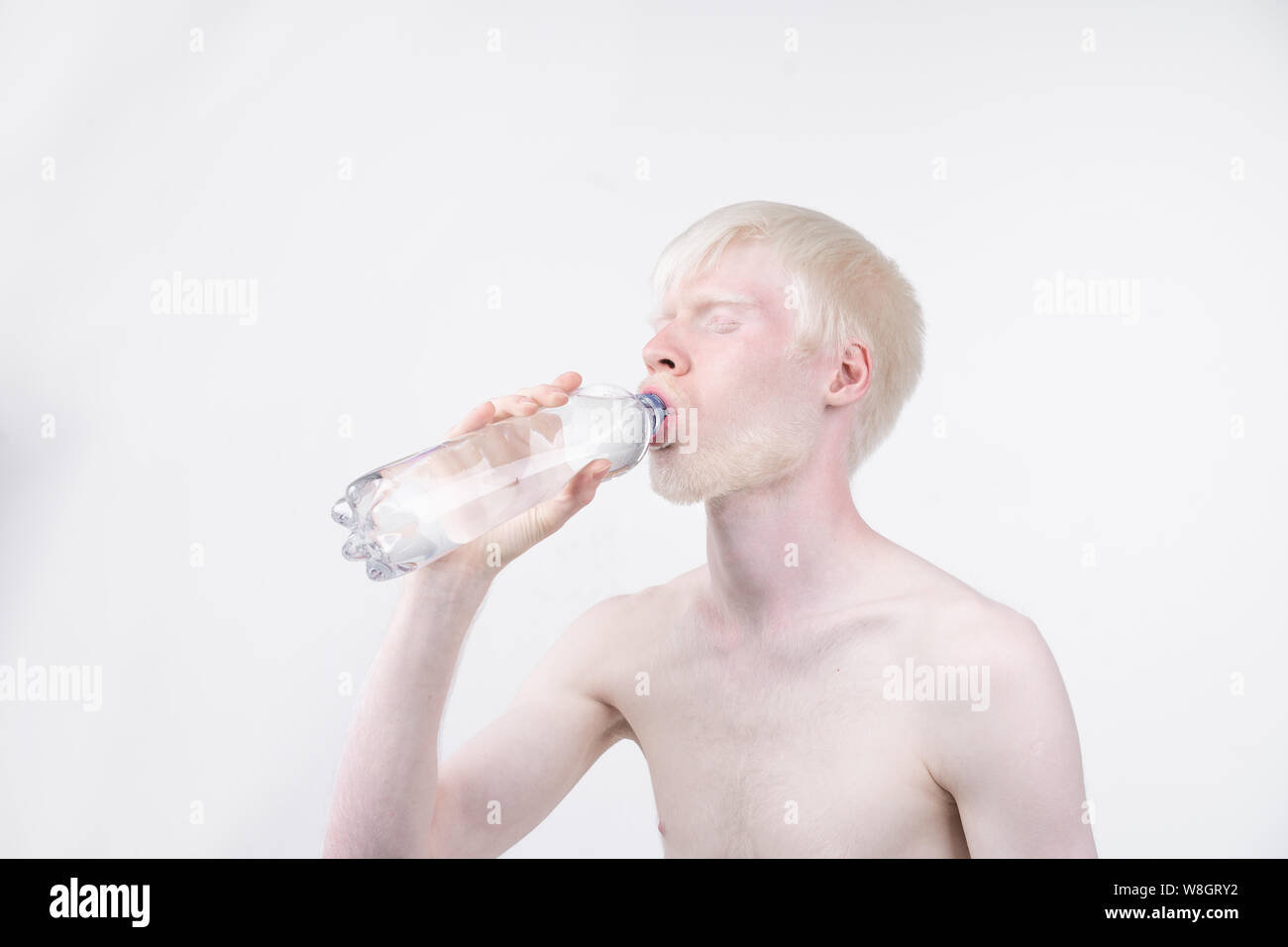 portrait of an albino man in studio dressed t-shirt isolated on a white ...