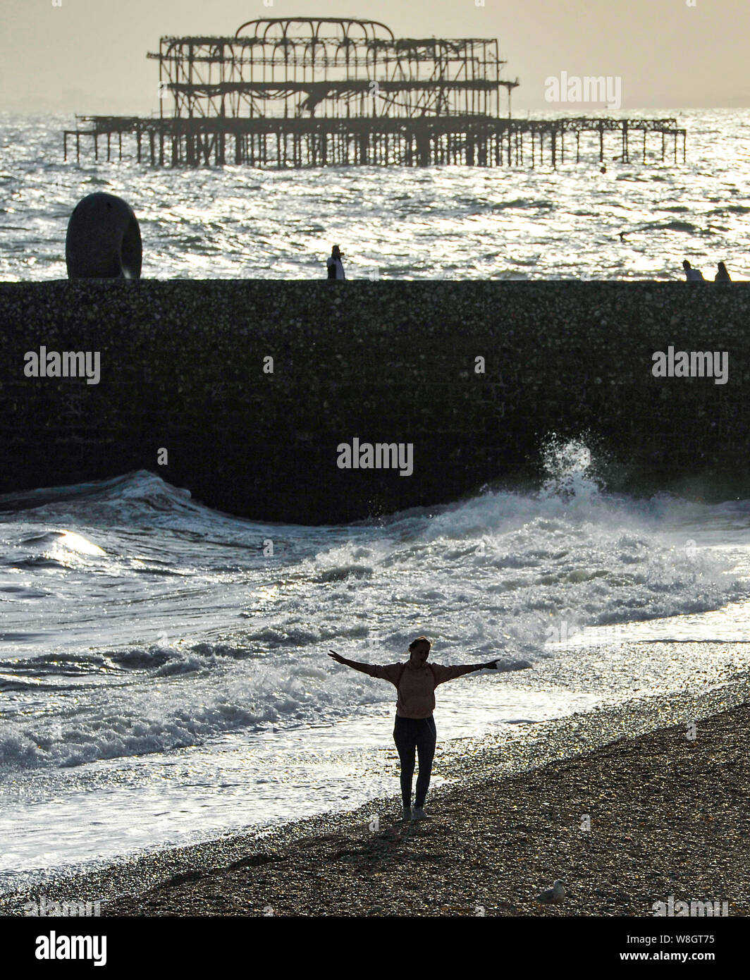 Brighton, UK. 9th Aug, 2019. Visitors watch the waves crash in on ...