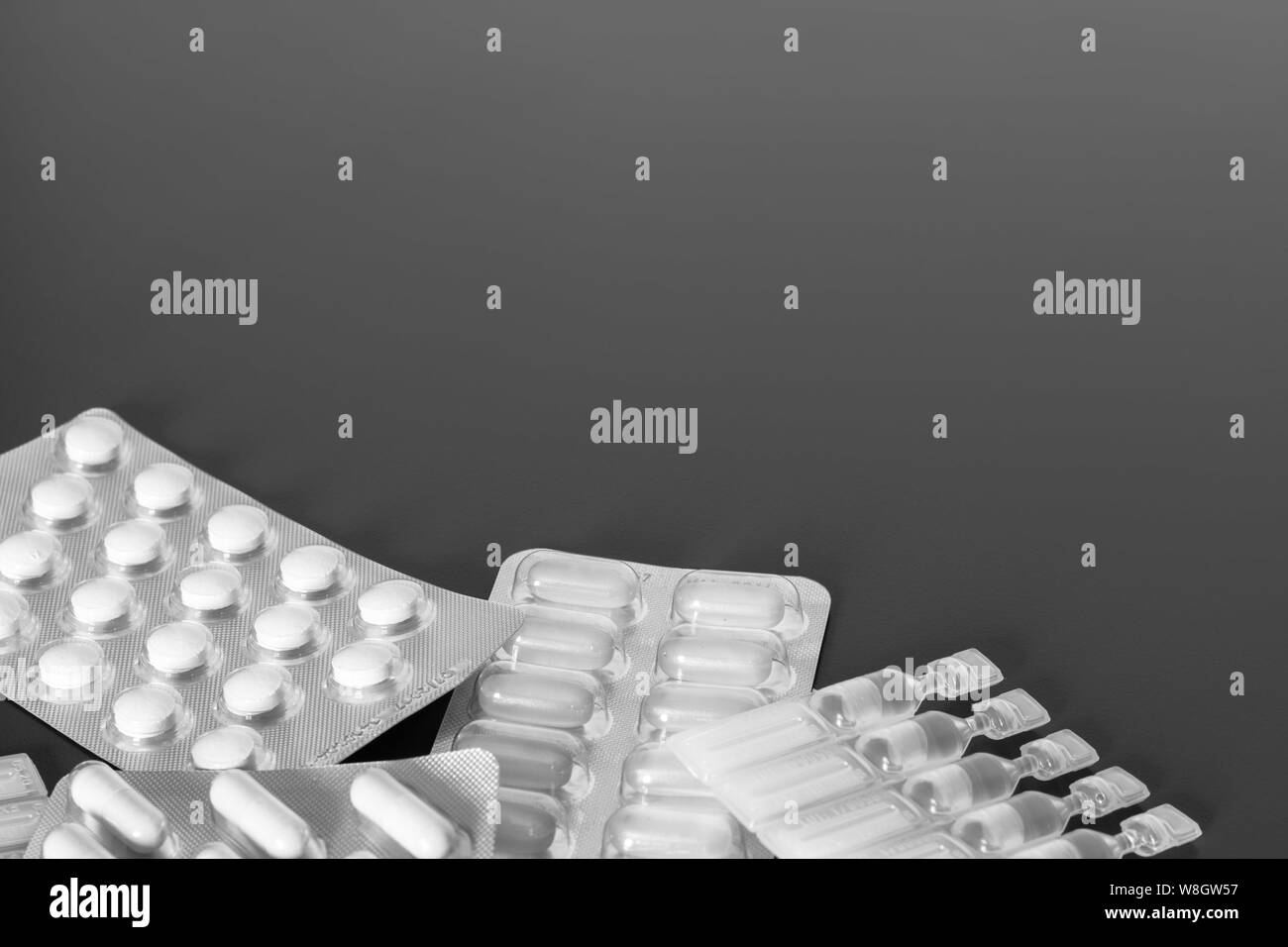 Pills or medicine lying on the grey table, drug abuse Stock Photo - Alamy