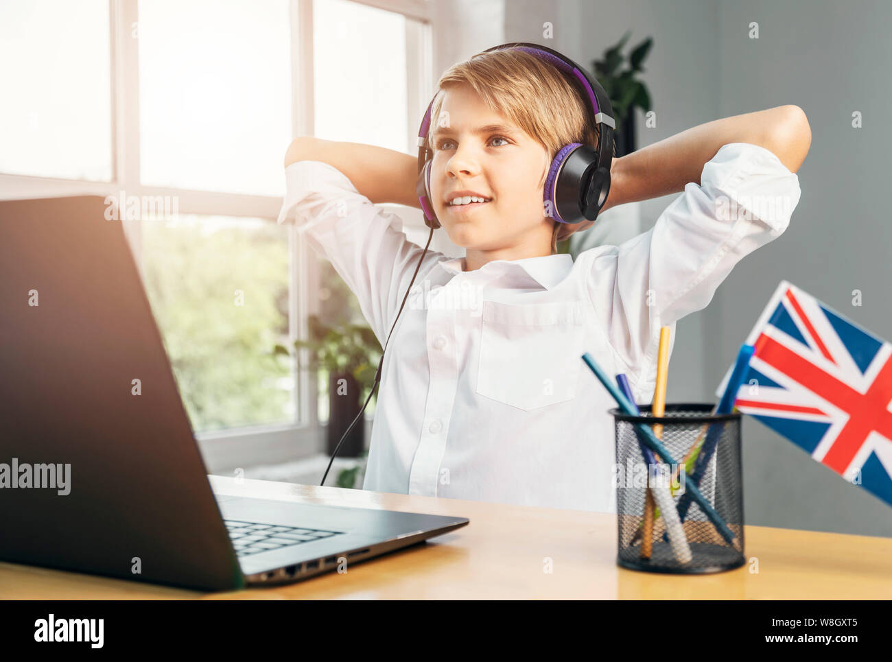 Smart smiling kid enjoys his success in studying English Stock Photo ...