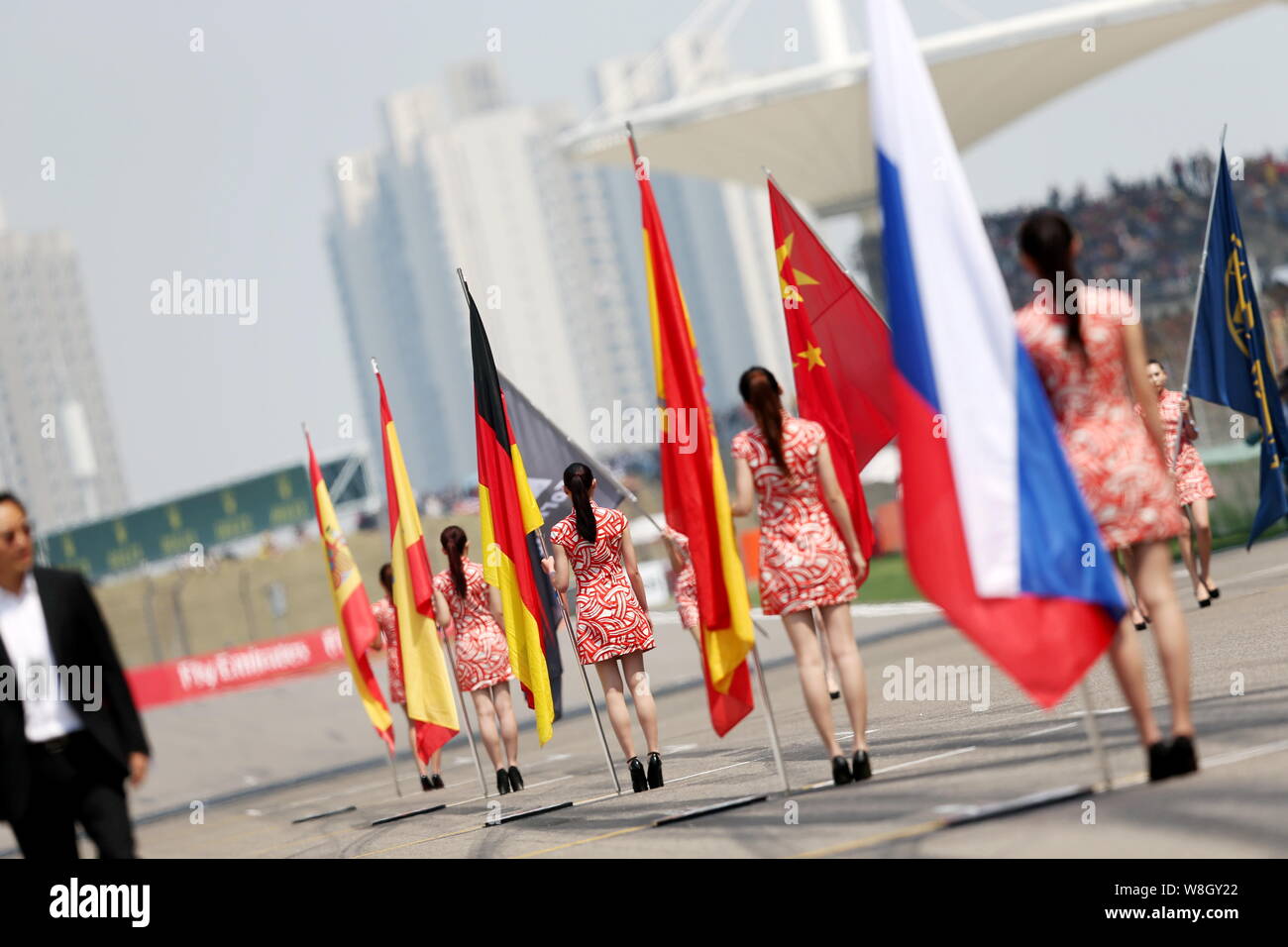 Hostesses pose with national flags on the track ahead of the 2015 ...
