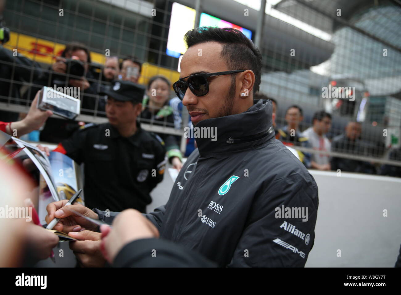 British F1 driver Lewis Hamilton of Mercedes signs autographs for fans ...