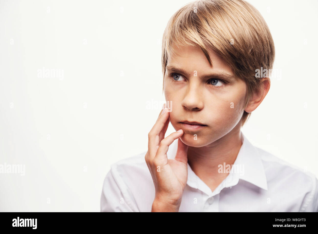 Thoughtful boy holding chin hi-res stock photography and images - Alamy