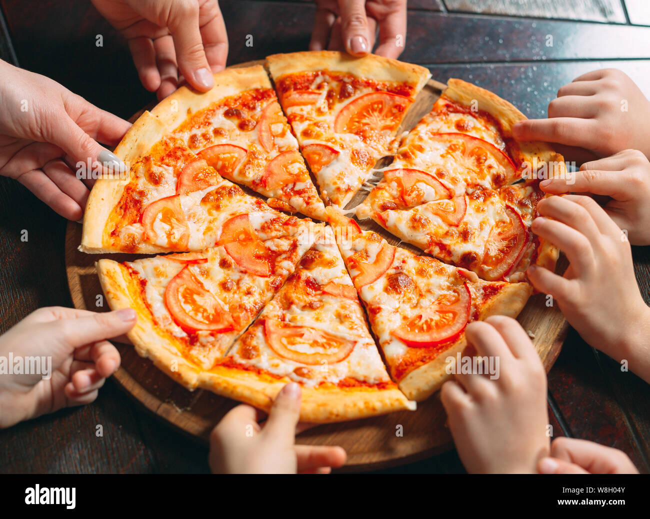 Hands taking pizza slices hi-res stock photography and images - Alamy