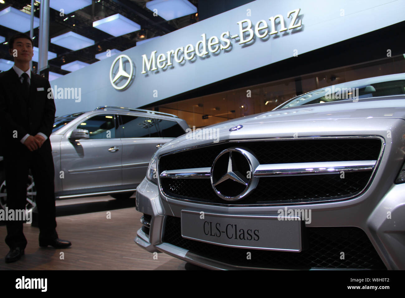 --FILE--A Chinese employee stands next to a Mercedes-Benz CLS Class ...