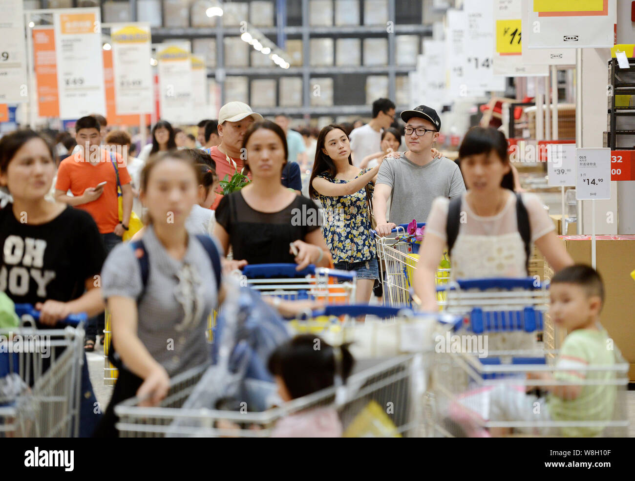 --FILE--Chinese customers push carts for shopping at a furnishing store ...
