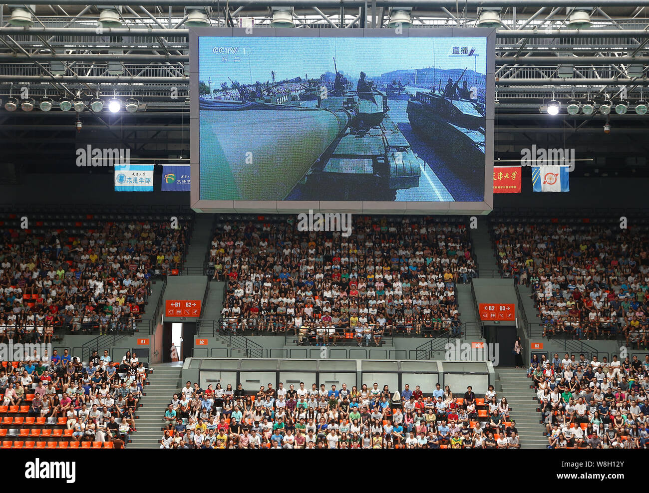 Chinese students and teachers watch the live TV broadcast of the ...