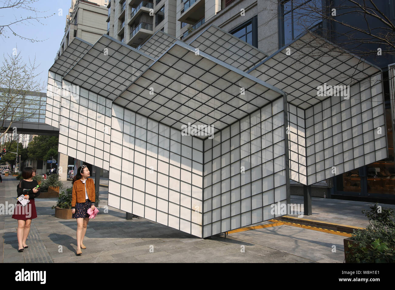 Visitors look at an art installation during a shop window design ...
