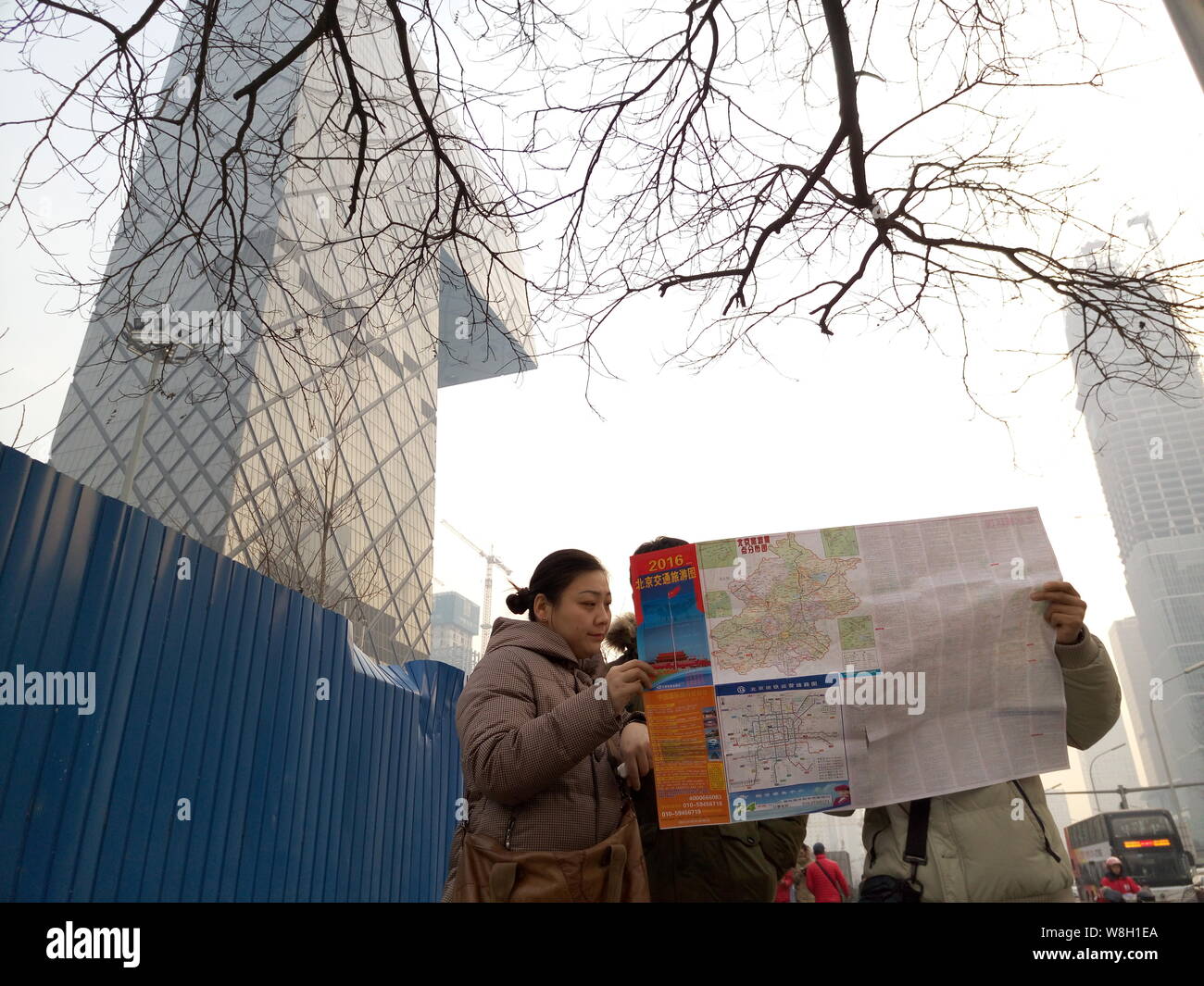 --FILE--Tourists look at a map near the CCTV Tower, the headquarters of ...