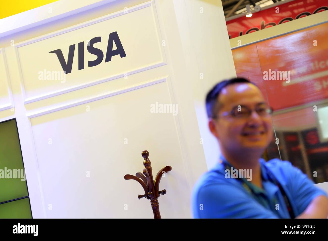 --FILE--A visitor smiles at the stand of Visa during the GSMA Mobile ...