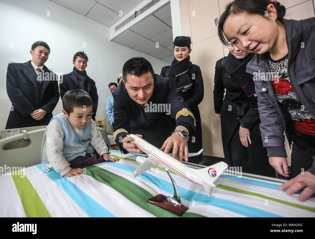 A Chinese pilot of China Eastern Airlines, center, gives a model plane ...