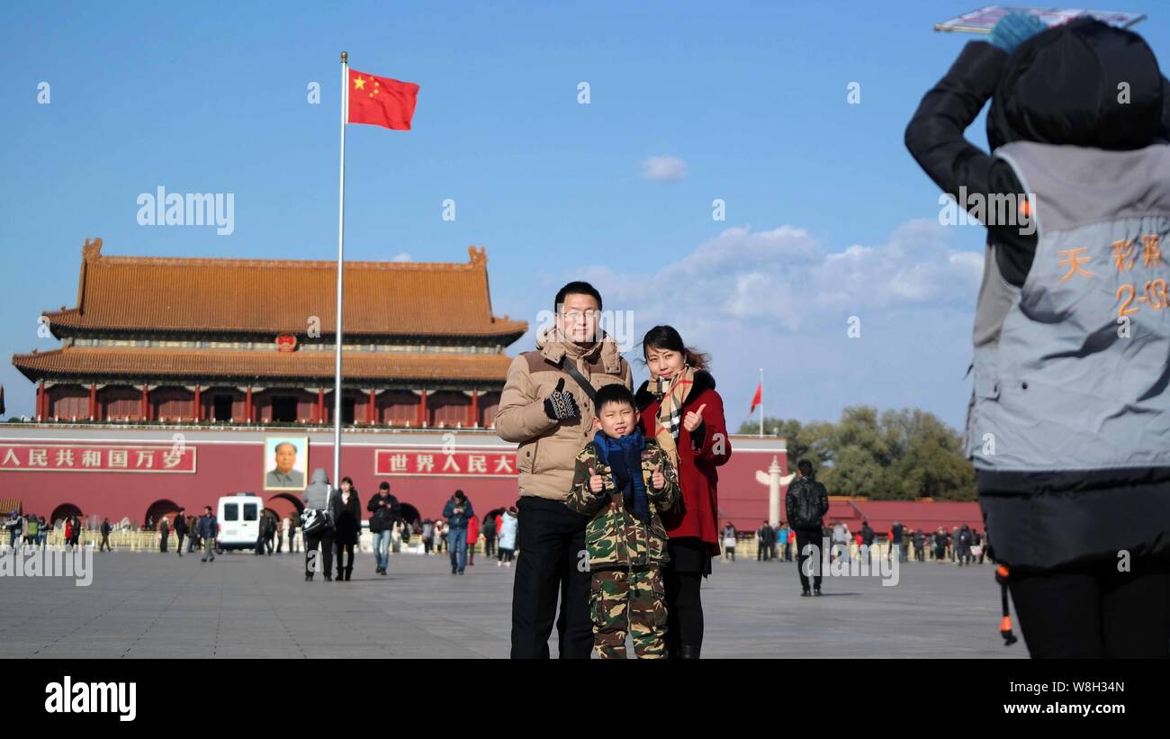 --FILE--A Chinese family of three poses for a photo on Tian'anmen ...