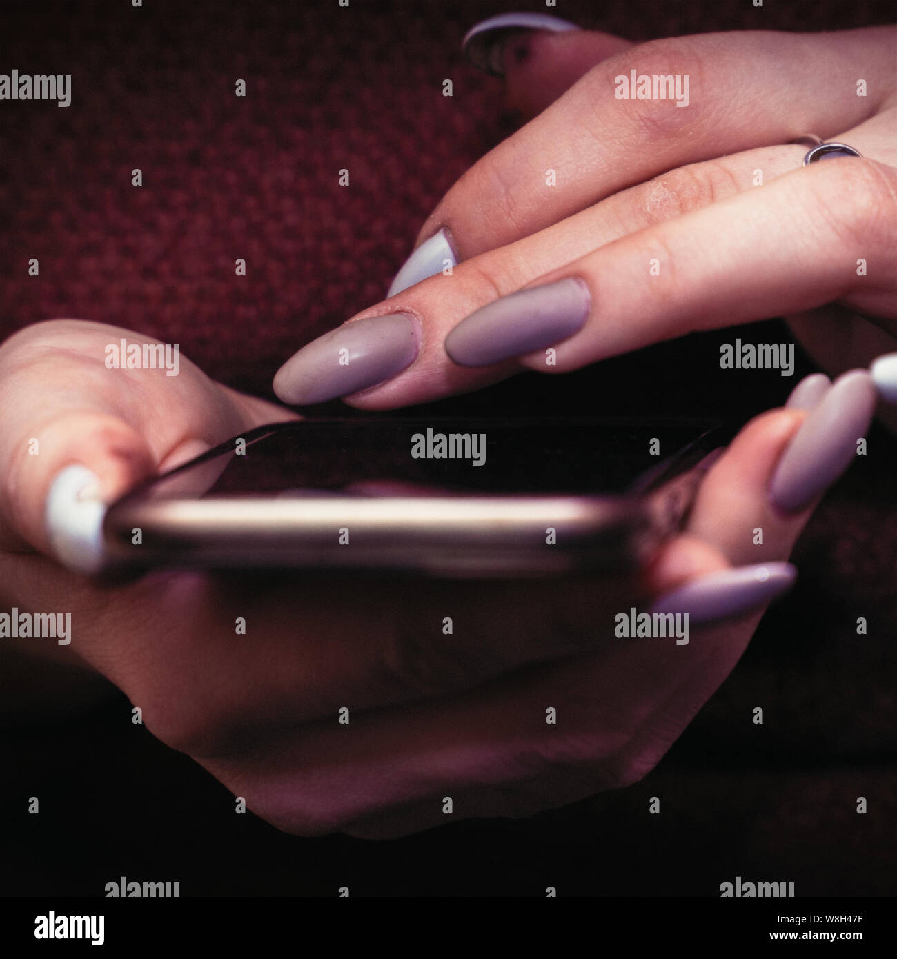 The girl touches her fingers to the phone screen. The girl has a ...