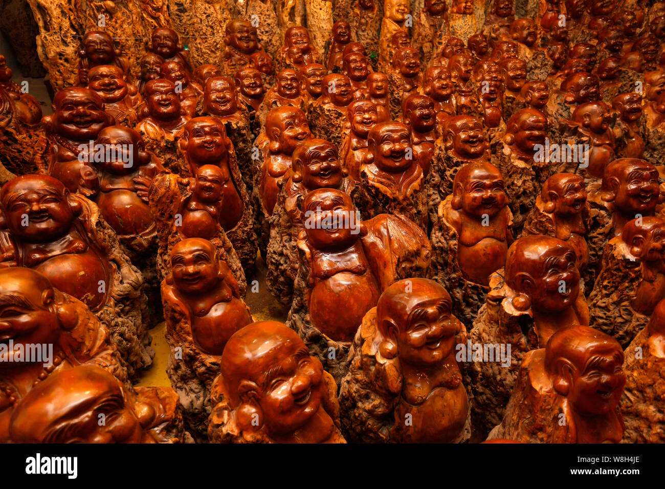 Wooden Buddha statues are on display at an exhibition center in ...