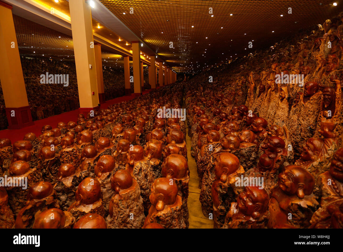Wooden Buddha statues are on display at an exhibition center in ...