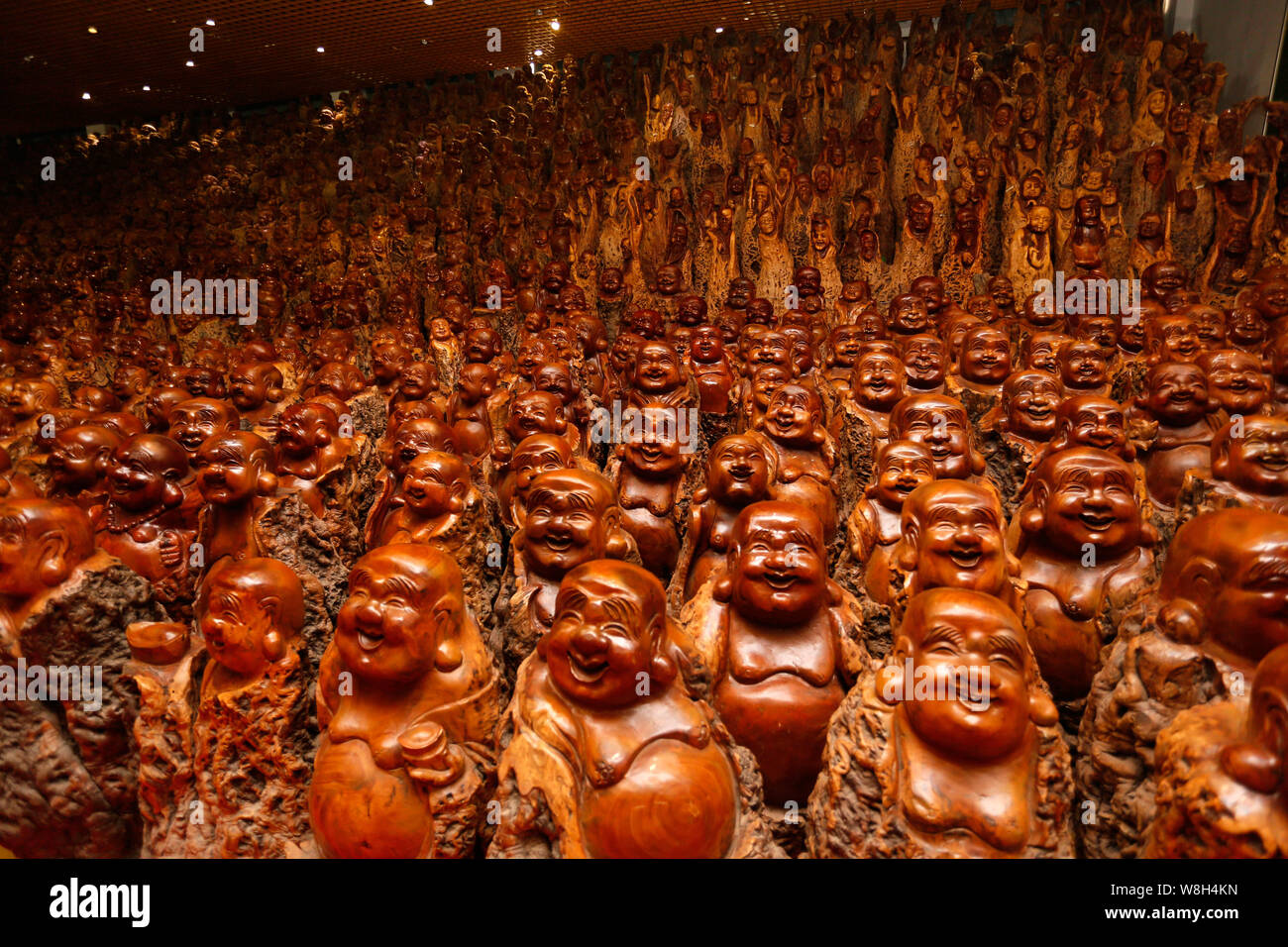 Wooden Buddha statues are on display at an exhibition center in ...