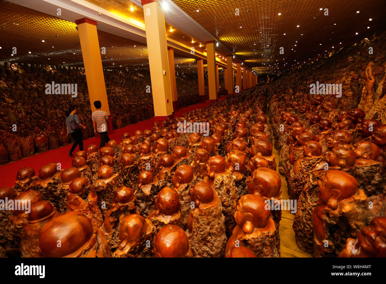 Wooden Buddha statues are on display at an exhibition center in ...