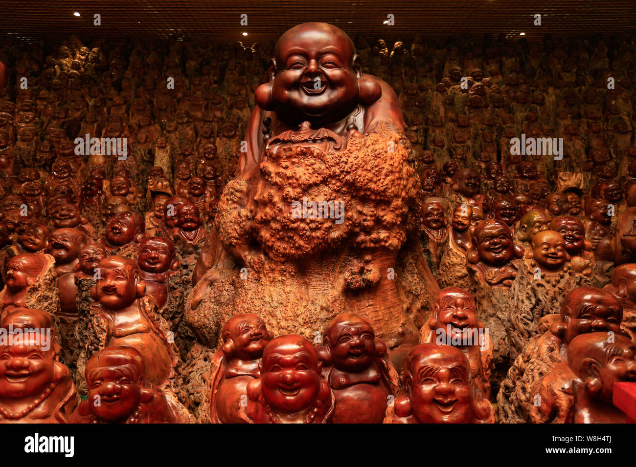 Wooden Buddha statues are on display at an exhibition center in ...