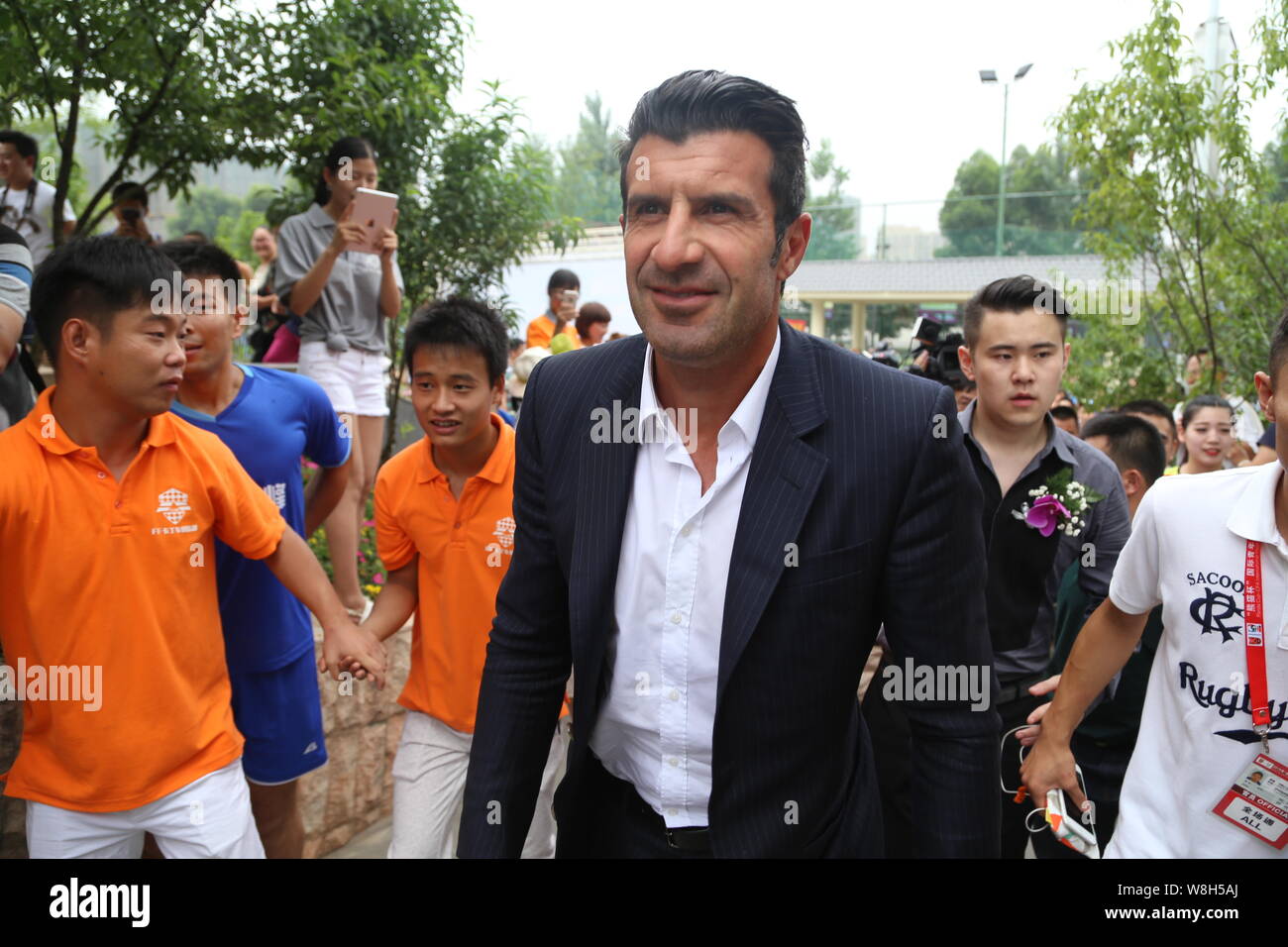 Portuguese football star Luis Figo, right, smiles as he arrives at the ...
