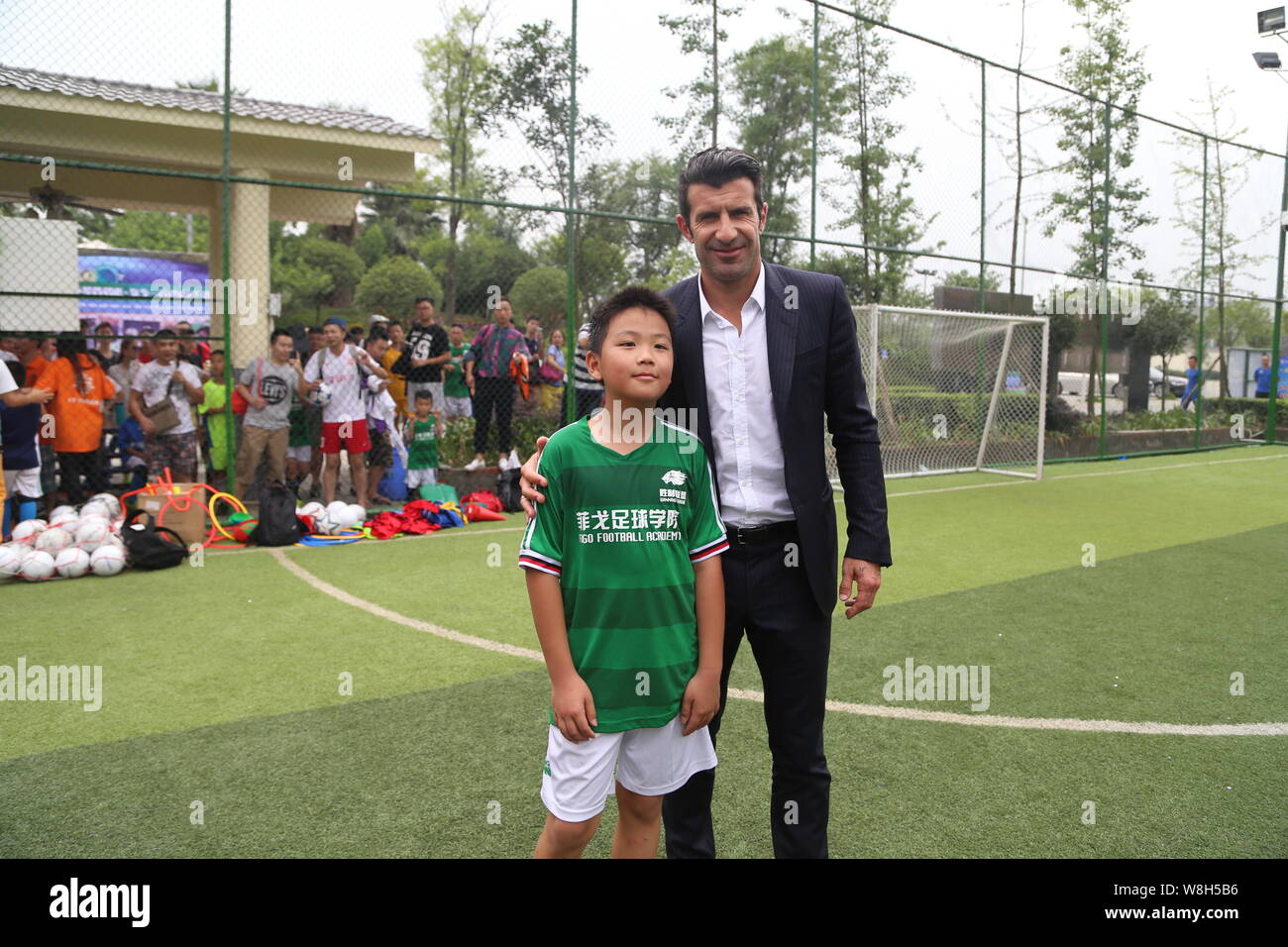 Portuguese football star Luis Figo, right, poses with a young boy ...