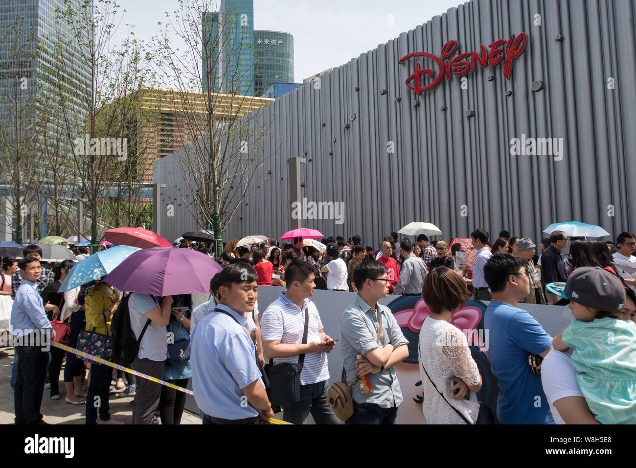 Customers queue up in front of the newly-opened Shanghai Disney ...