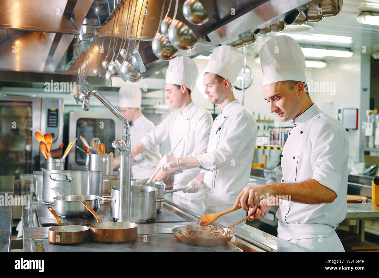 Modern kitchen. Cooks prepare meals on the stove in the kitchen of the ...