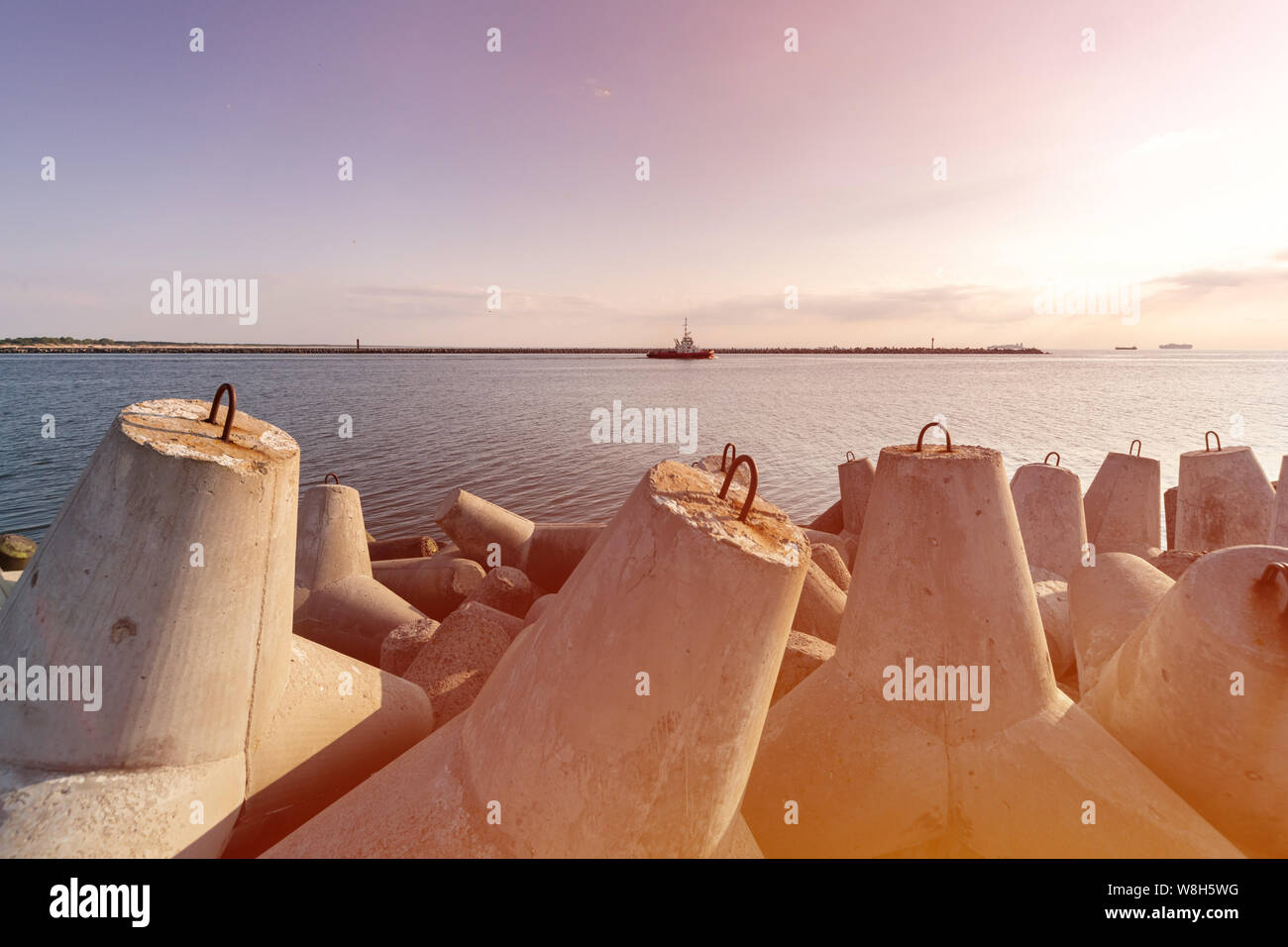 Ship-tugboat goes in high seas to tow cargo ship to port. Beautiful ...
