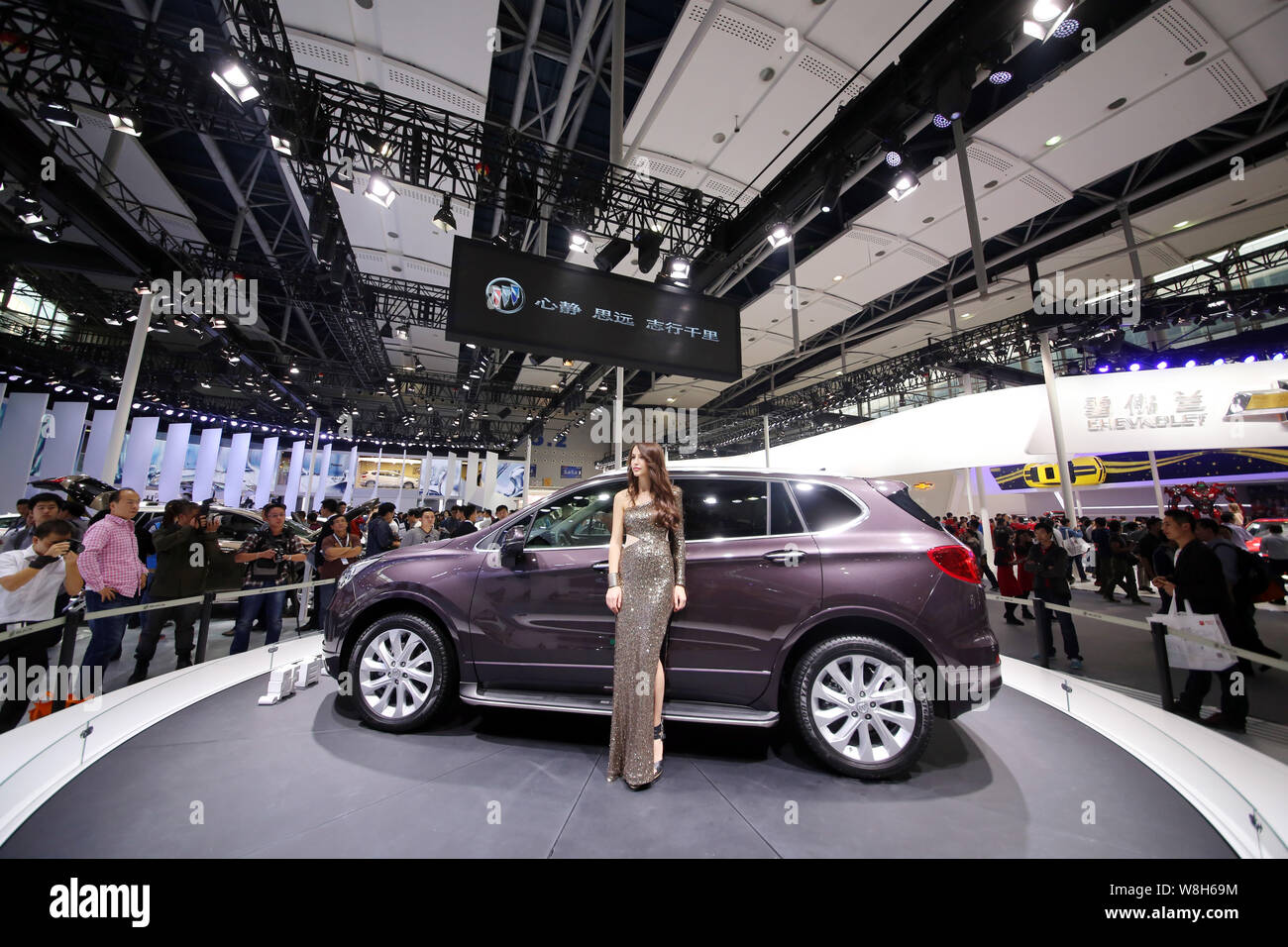 --FILE--A model poses with a Buick Envision of SAIC-GM, a joint venture ...