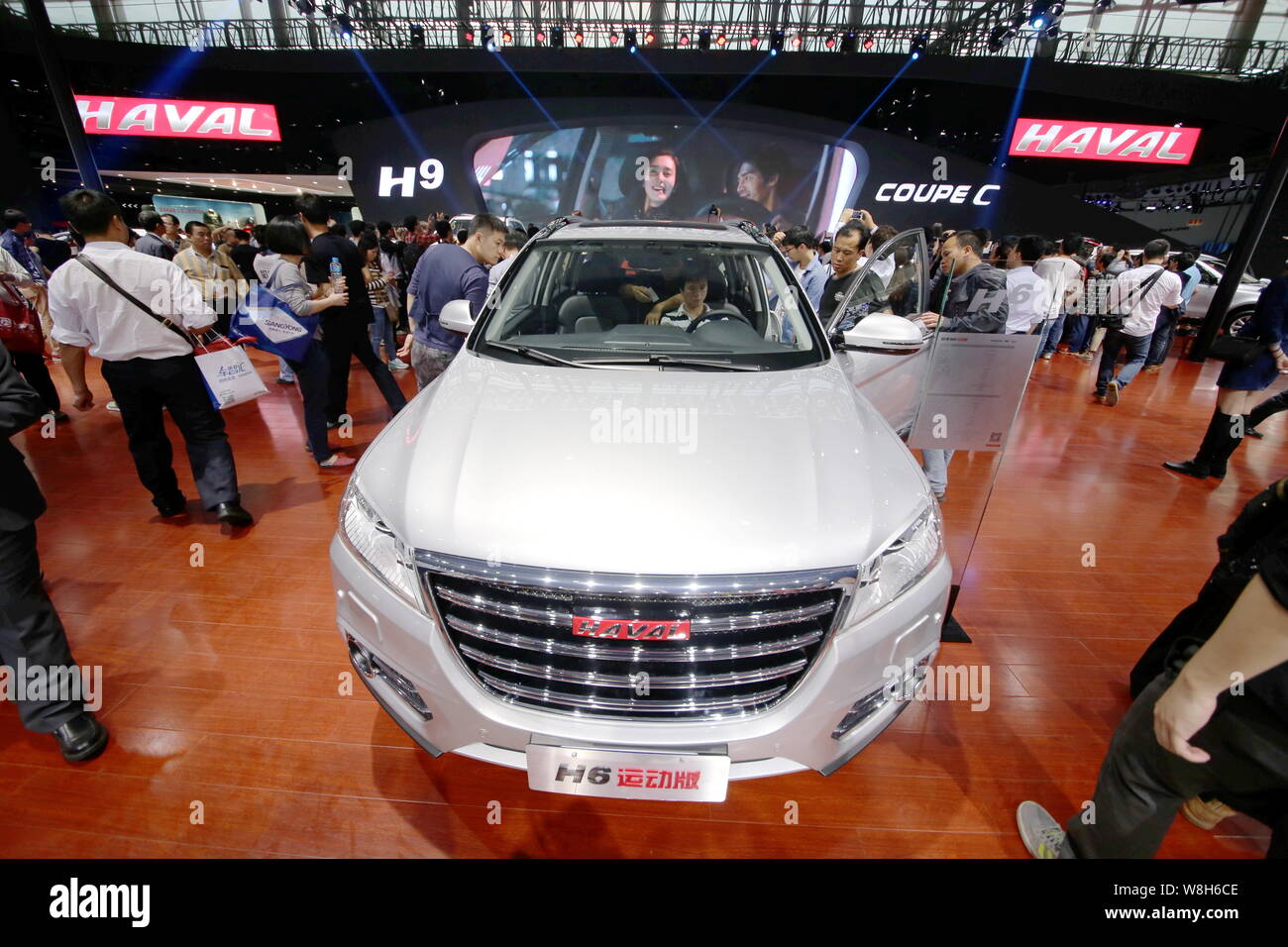 --FILE--Visitors try out or look at a Haval H6 SUV of Great Wall Motors ...