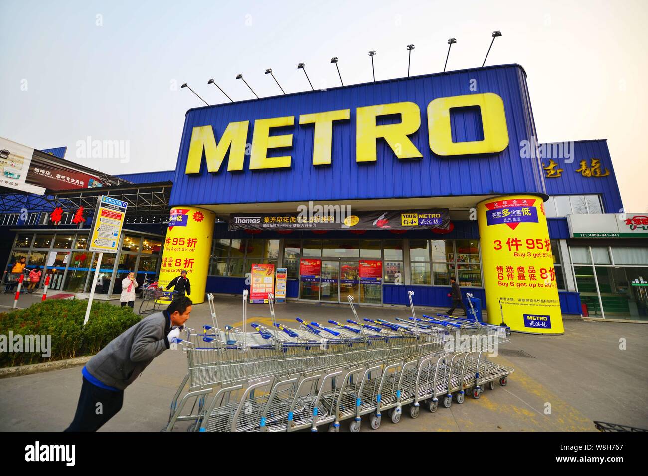 --FILE--A Chinese worker pushes shopping carts at a supermarket of ...