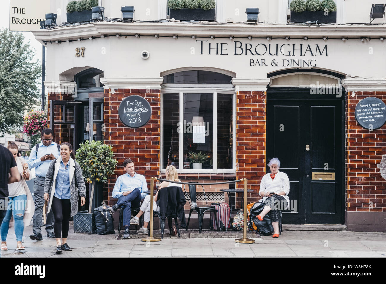 London, UK - July 16, 2019: People sitting outside The Brougham pub in ...