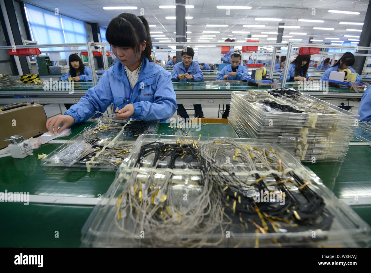 Female Chinese workers produce electronic accessories on the assembly ...