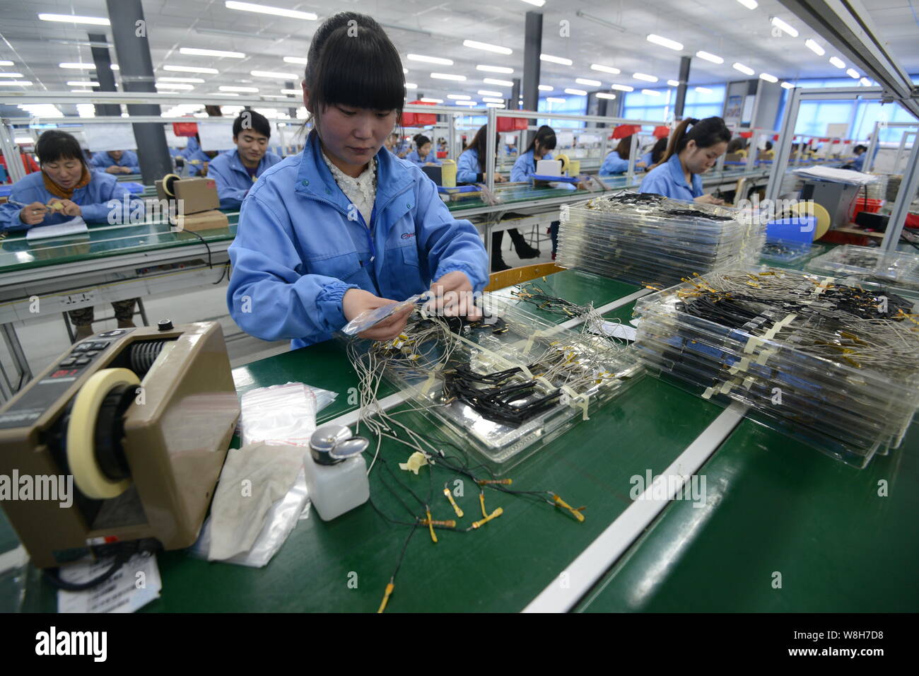 Female Chinese workers produce electronic accessories on the assembly ...