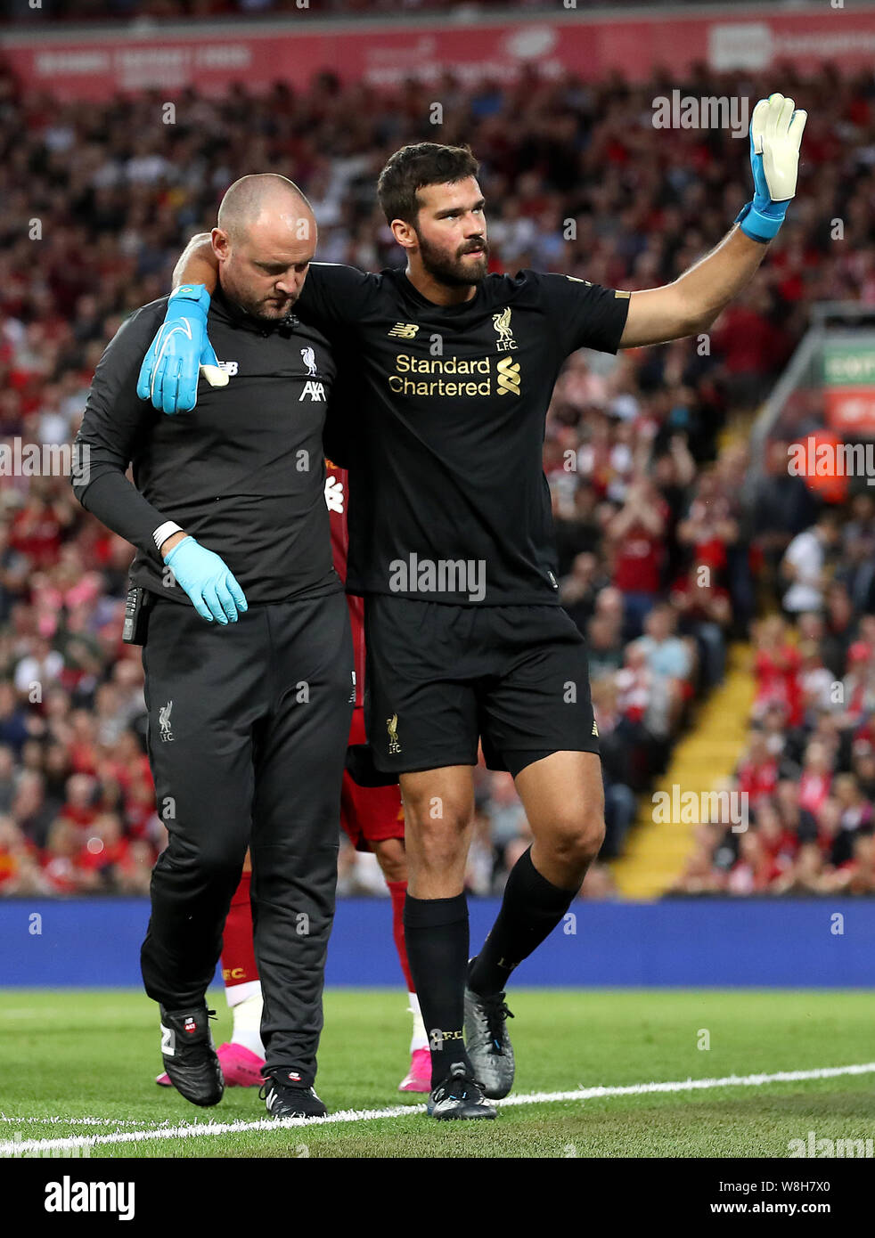 Liverpool goalkeeper Alisson (right) leaves the pitch after picking up ...
