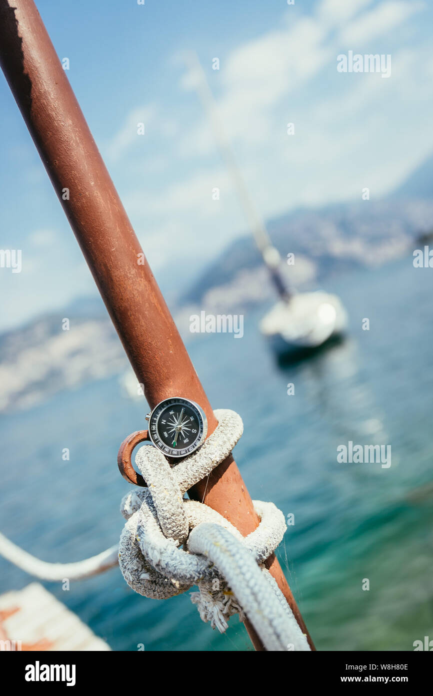 Compass on a lying on a sailing rope, ocean and sailing boats in the ...