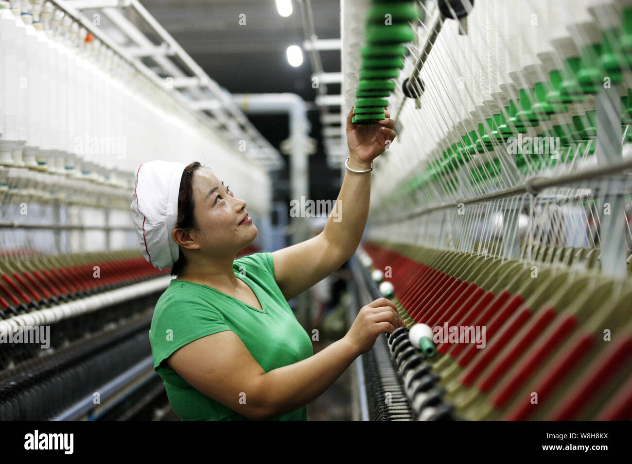 --FILE--A female Chinese worker handles production of yarn at a garment factory in Huaibei city ...