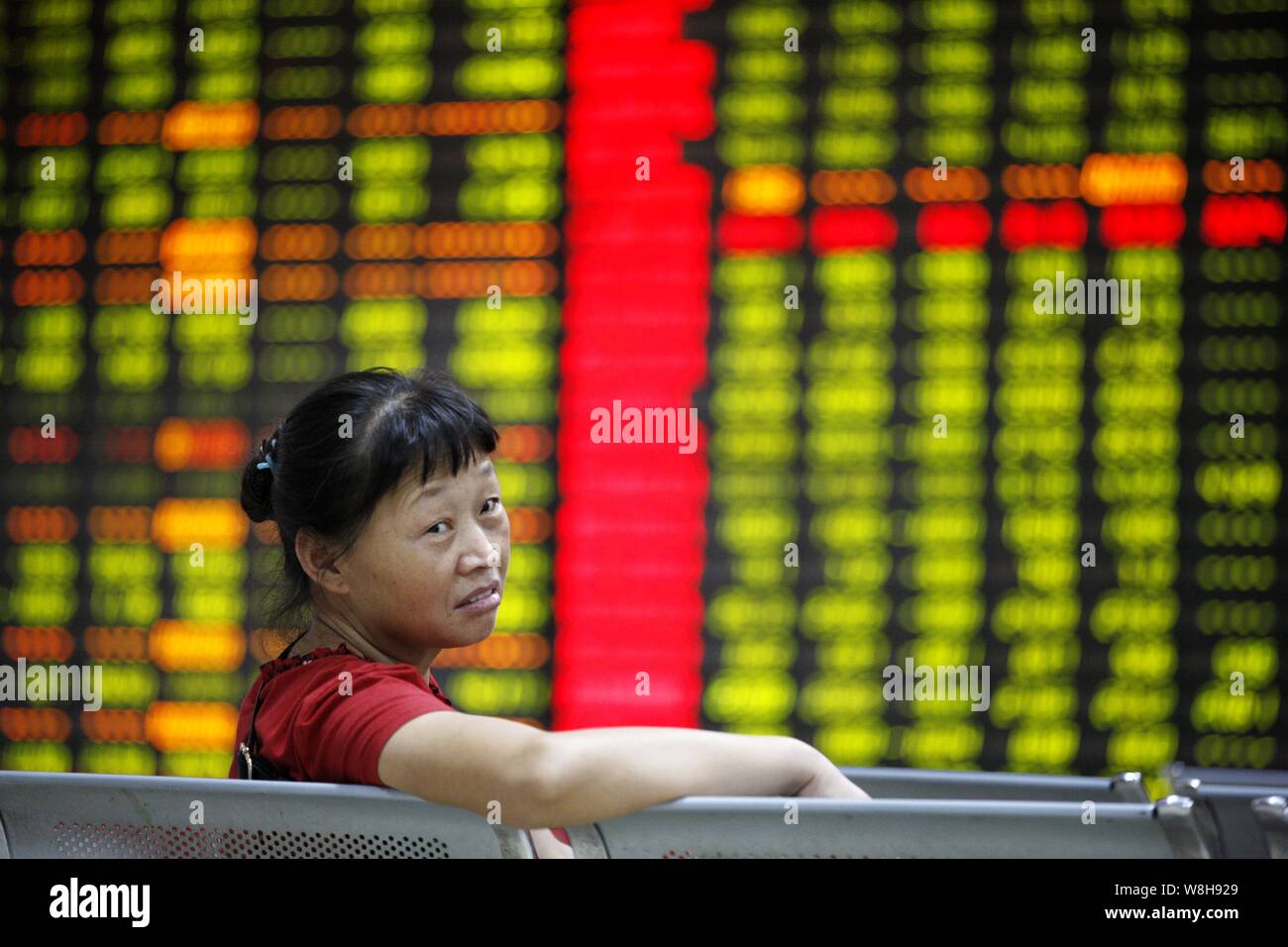 A concerned Chinese investor is pictured in front of a screen ...