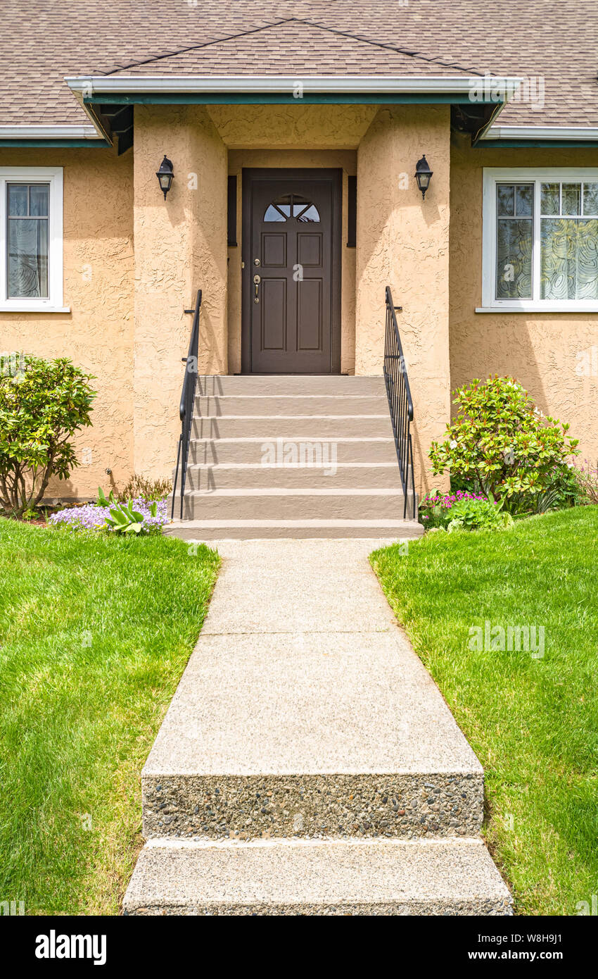 Main entrance of old family house with concrete pathway over front yard ...