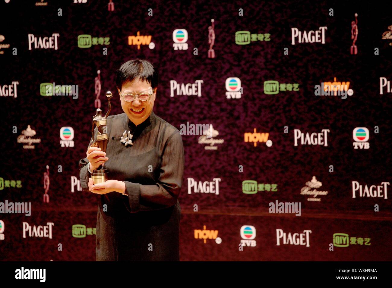 Hong Kong director Ann Hui poses with the trophy for the Best Director ...