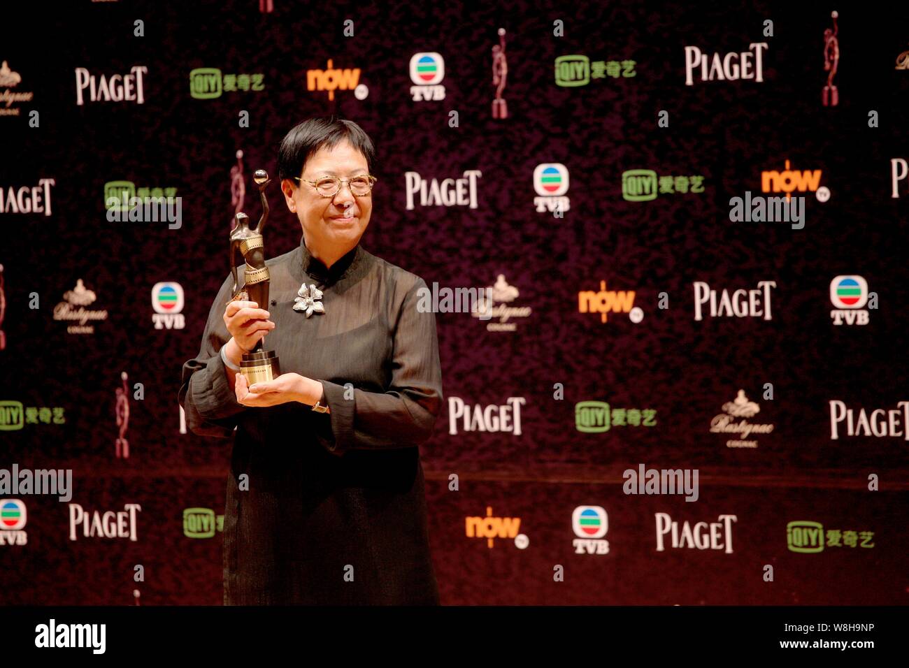 Hong Kong director Ann Hui poses with the trophy for the Best Director ...