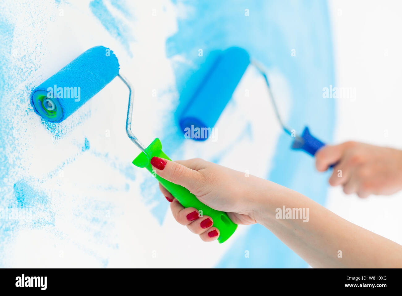 blue color painting wall with roller in hand Stock Photo - Alamy