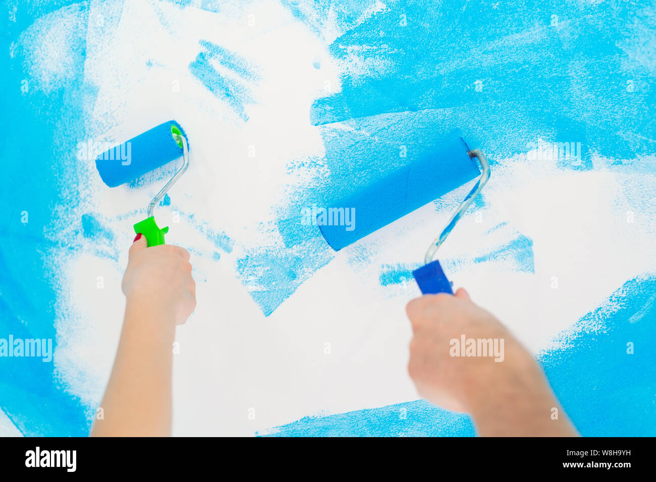 blue color painting wall with roller in hand Stock Photo - Alamy