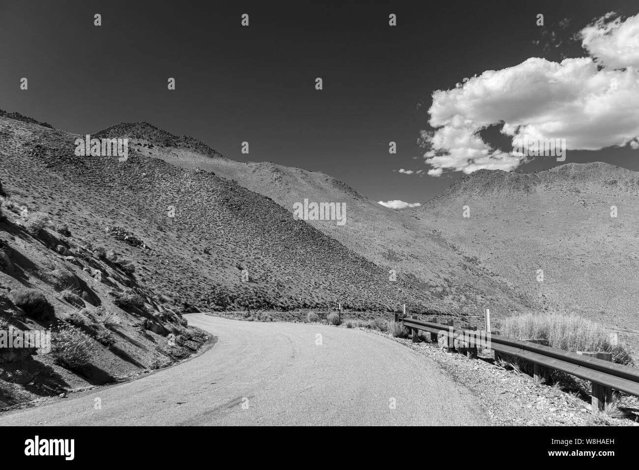 Uphill narrow paved mountain road with no lines. Curving road with ...