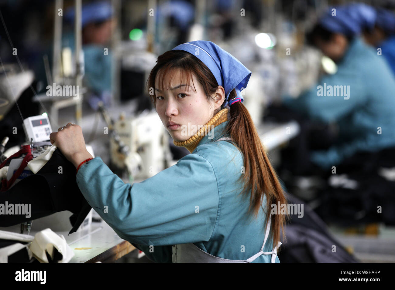 A female Chinese worker sews clothes at a garment factory in Huaibei ...