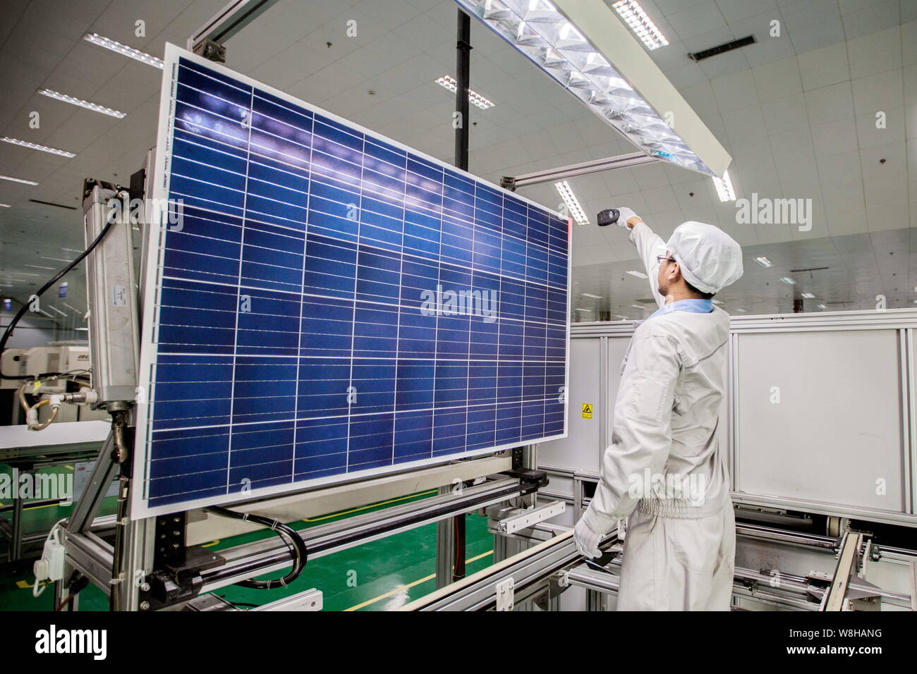 --FILE--A Chinese worker checks a solar panel at the plant of Shanghai ...