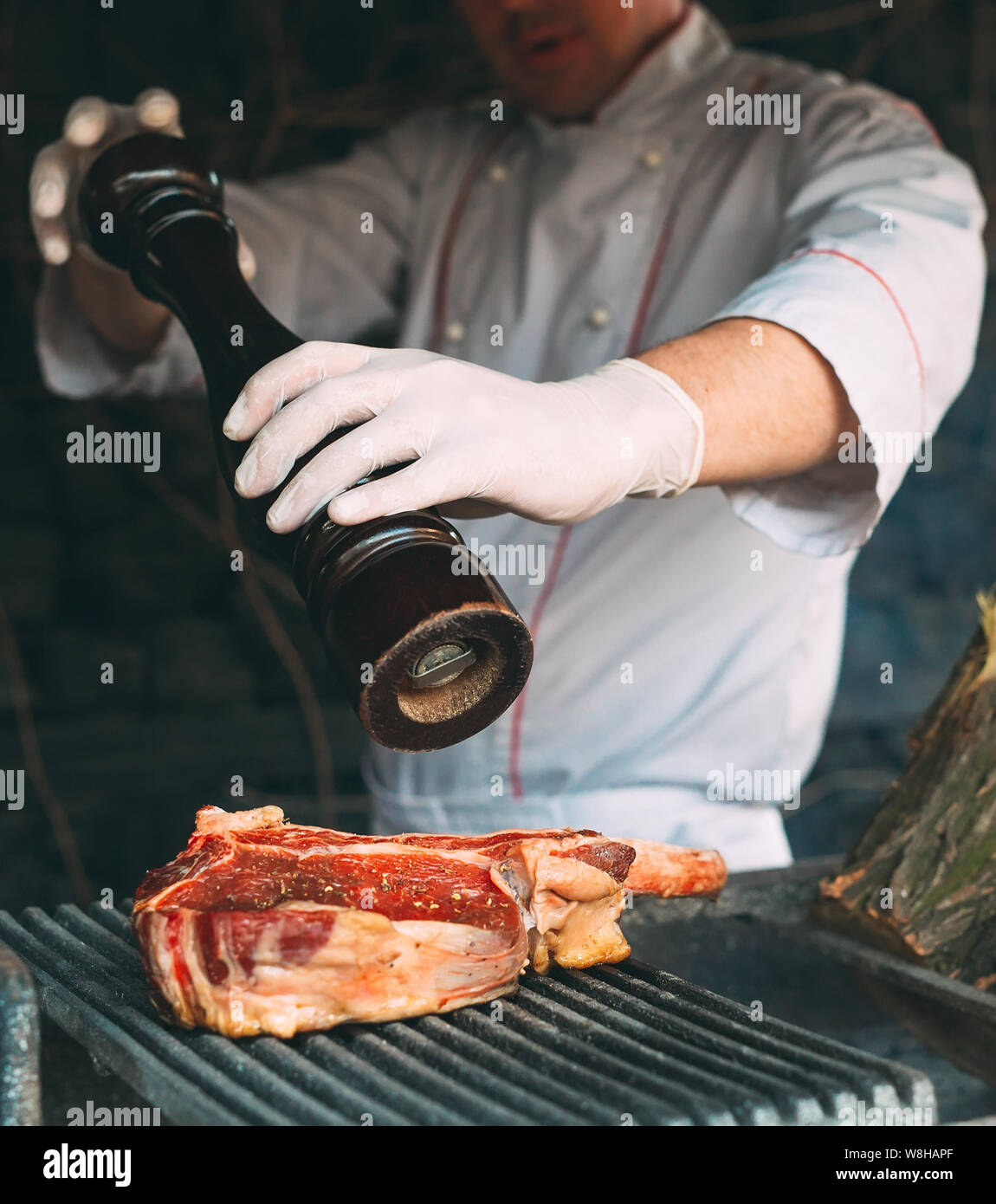 Chef pepper the steak on the fire Stock Photo - Alamy
