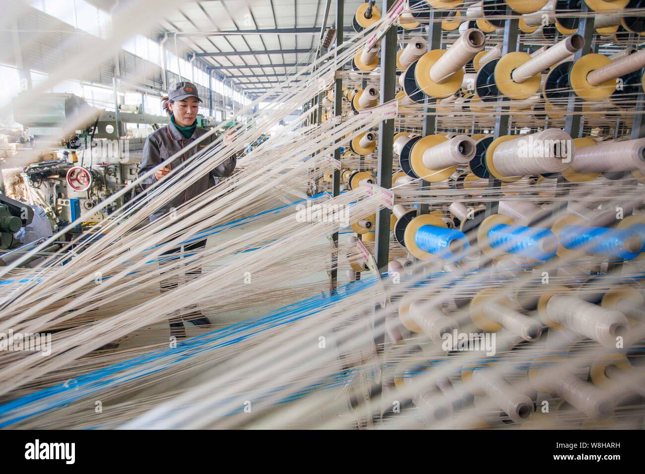 --FILE--A female Chinese worker handles production of yarn to be exported at a textile factory ...