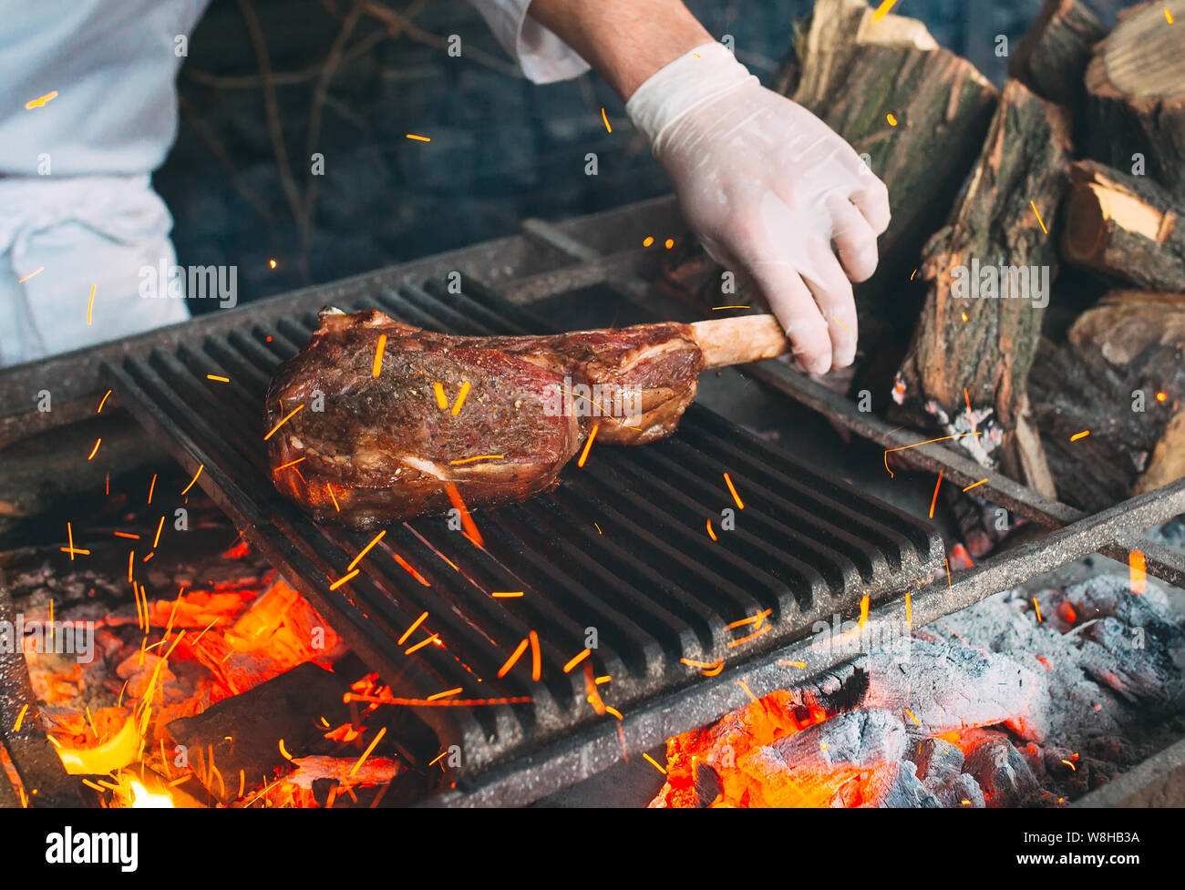 Chef Cooking steak. Cook turns the meat on the fire Stock Photo - Alamy